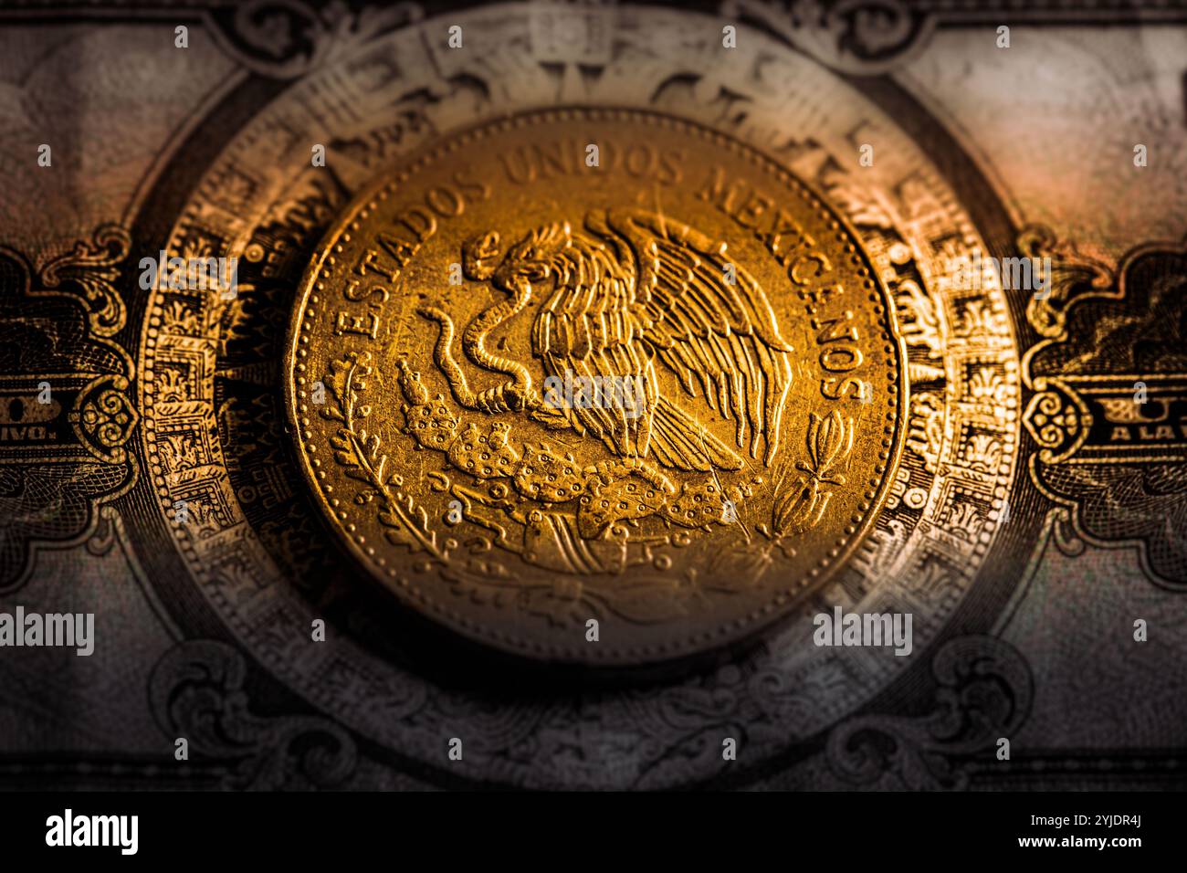 A close-up of a Mexican peso coin on an old currency note, highlighting ...