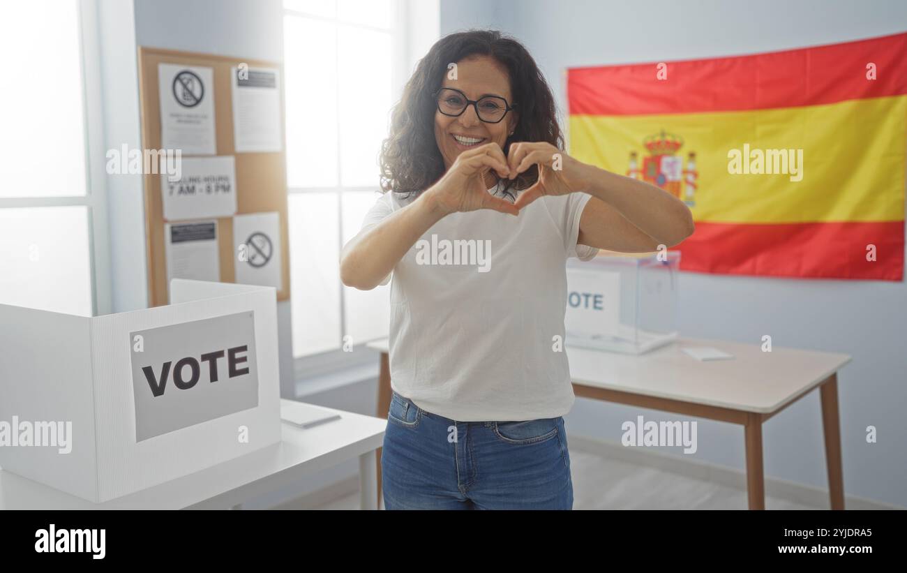 Woman voting indoors in spain, displaying heart gesture with national ...