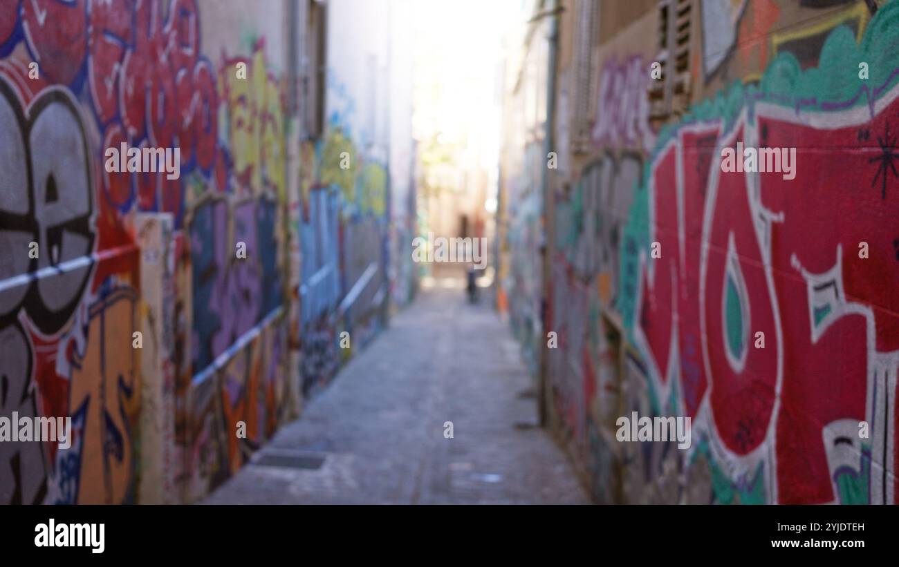Blurred view of graffiti-covered alleyway suggests urban street art ...