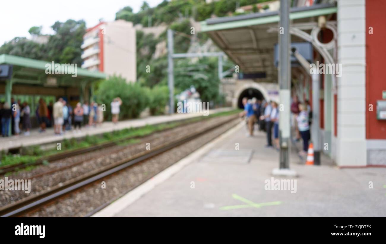 Crowd waiting on platform at train station with blurred commuters and ...
