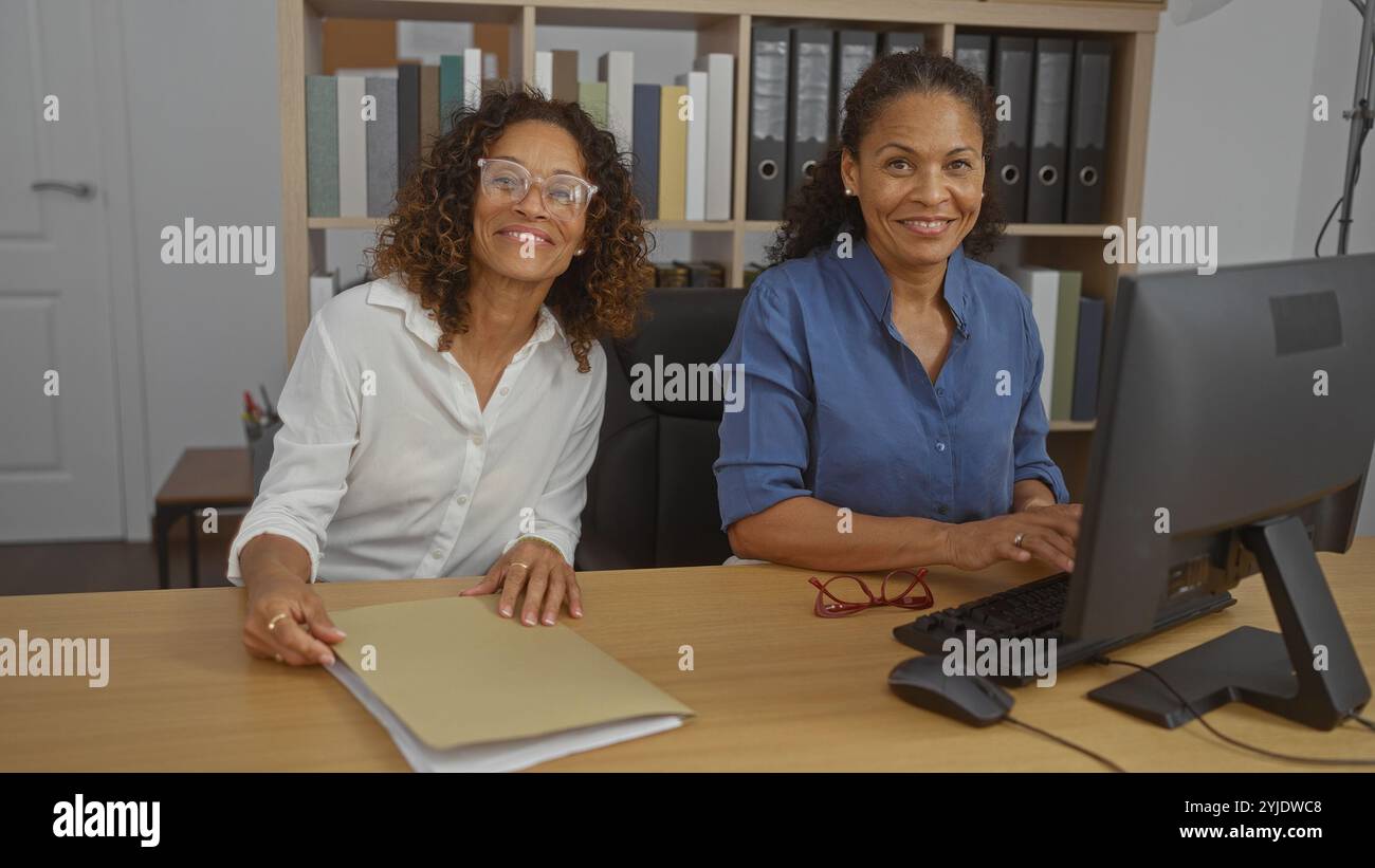 Latin women employees working together in a modern office setting ...