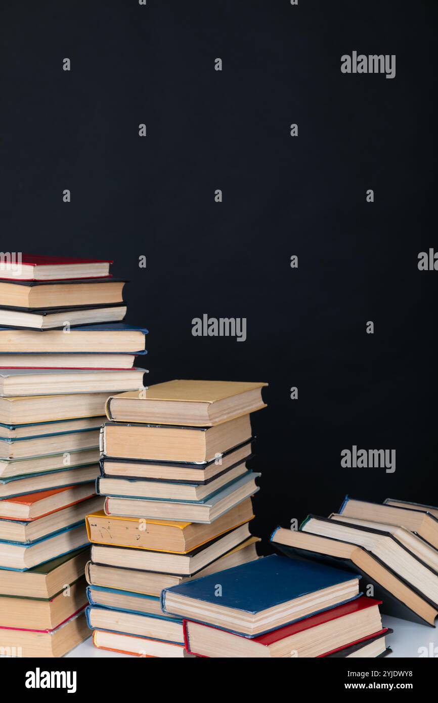 many stacks of books to study in the university library on a black ...