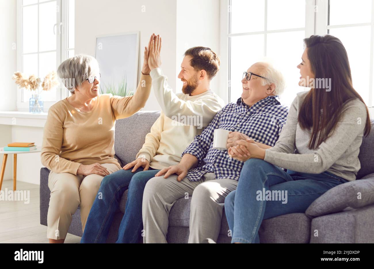 Family of senior old parents and their adult children sitting on sofa ...