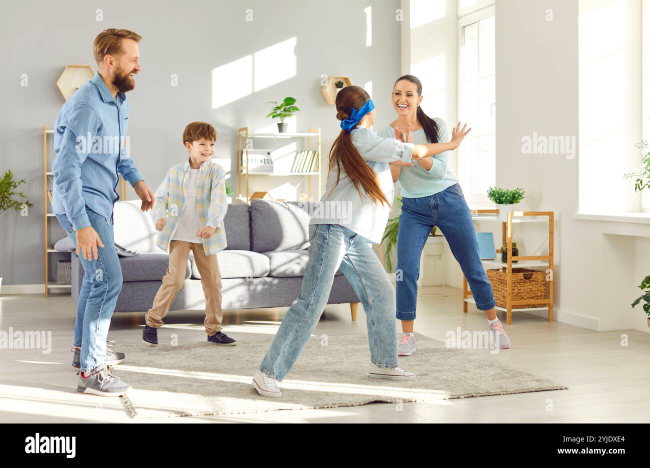 Happy funny playful family at home, mother and father with two children ...