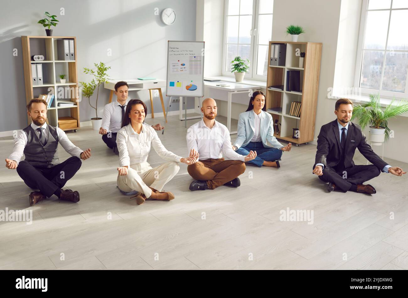 Business people meditating and having a rest in the office sitting on ...