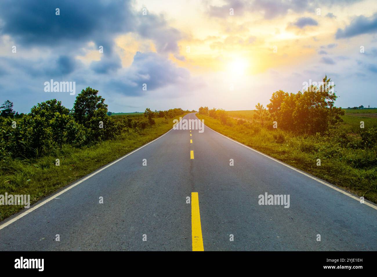 Beautiful sunset in a cloudy and clear sky with an asphalt road with ...