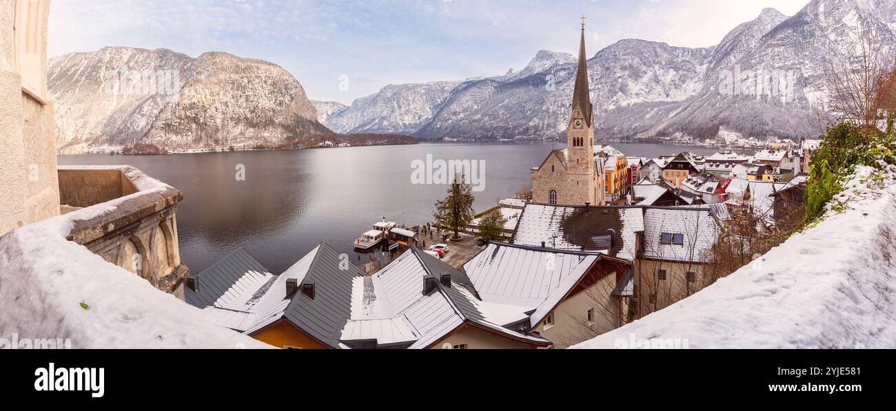 A panoramic winter view of Hallstatt village with snow-covered rooftops ...