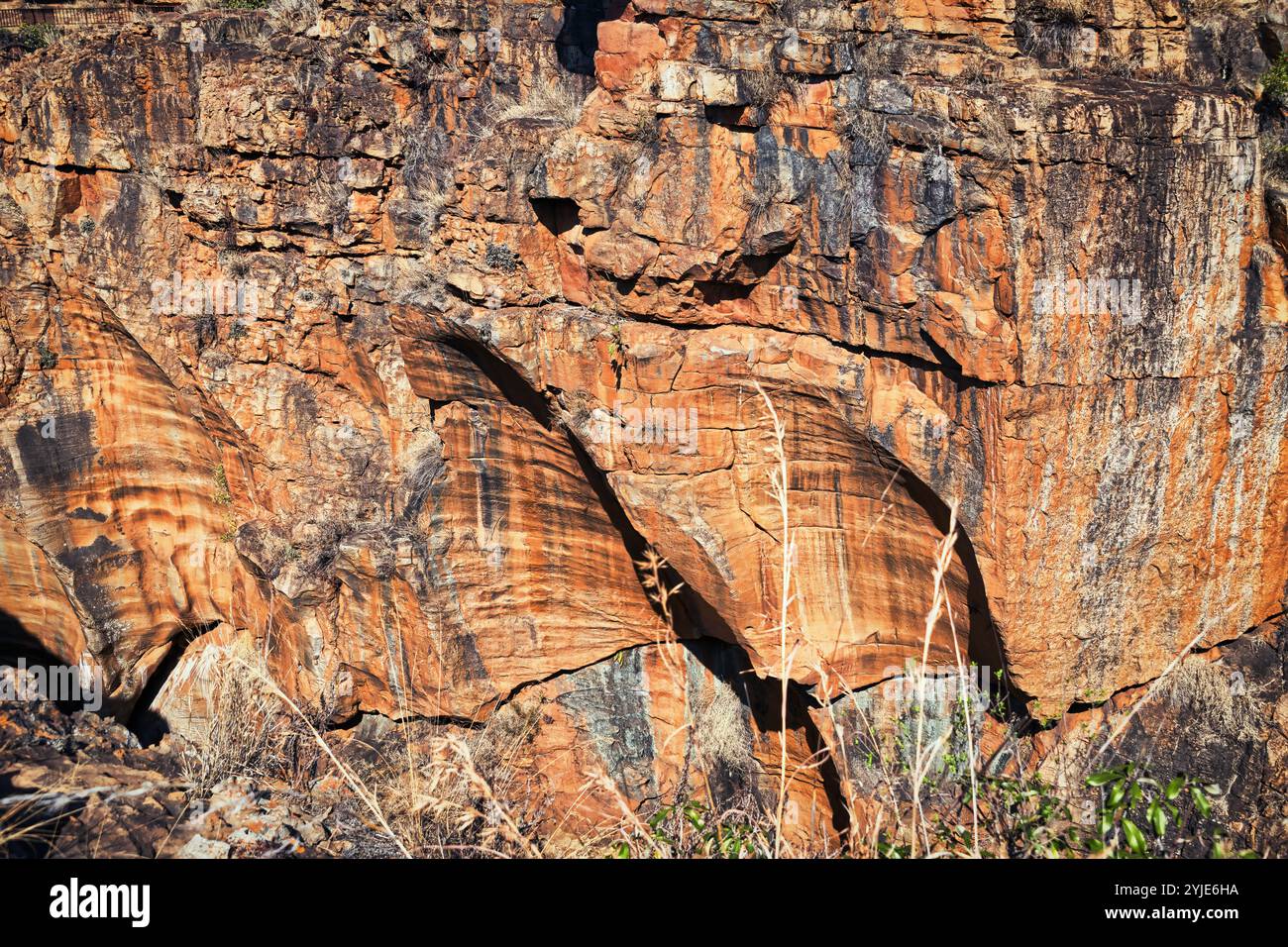 A striking view of rugged cliff rock formations bathed in warm sunlight ...