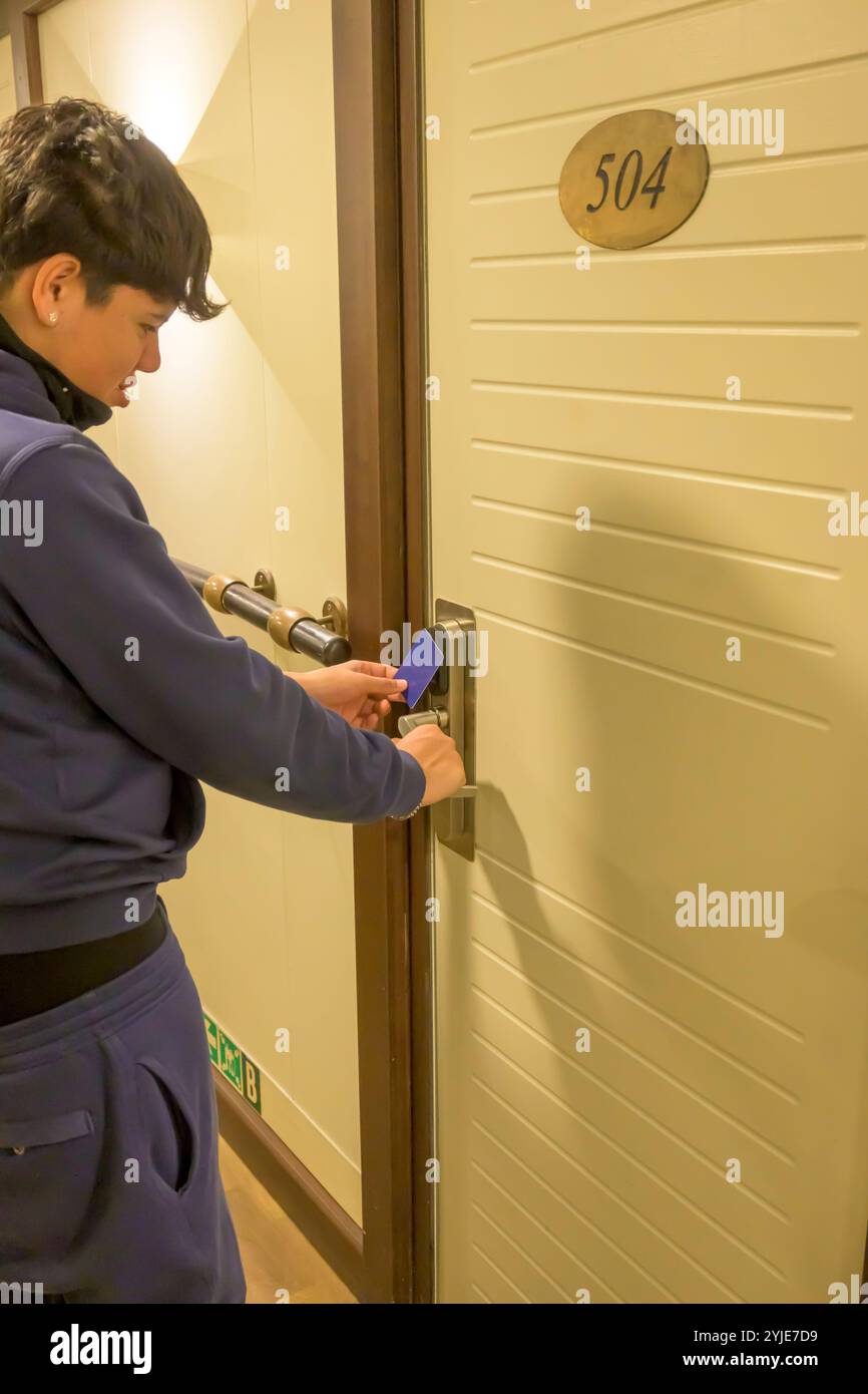 Latin young men opens a door with a keycard in a hallway, key ...