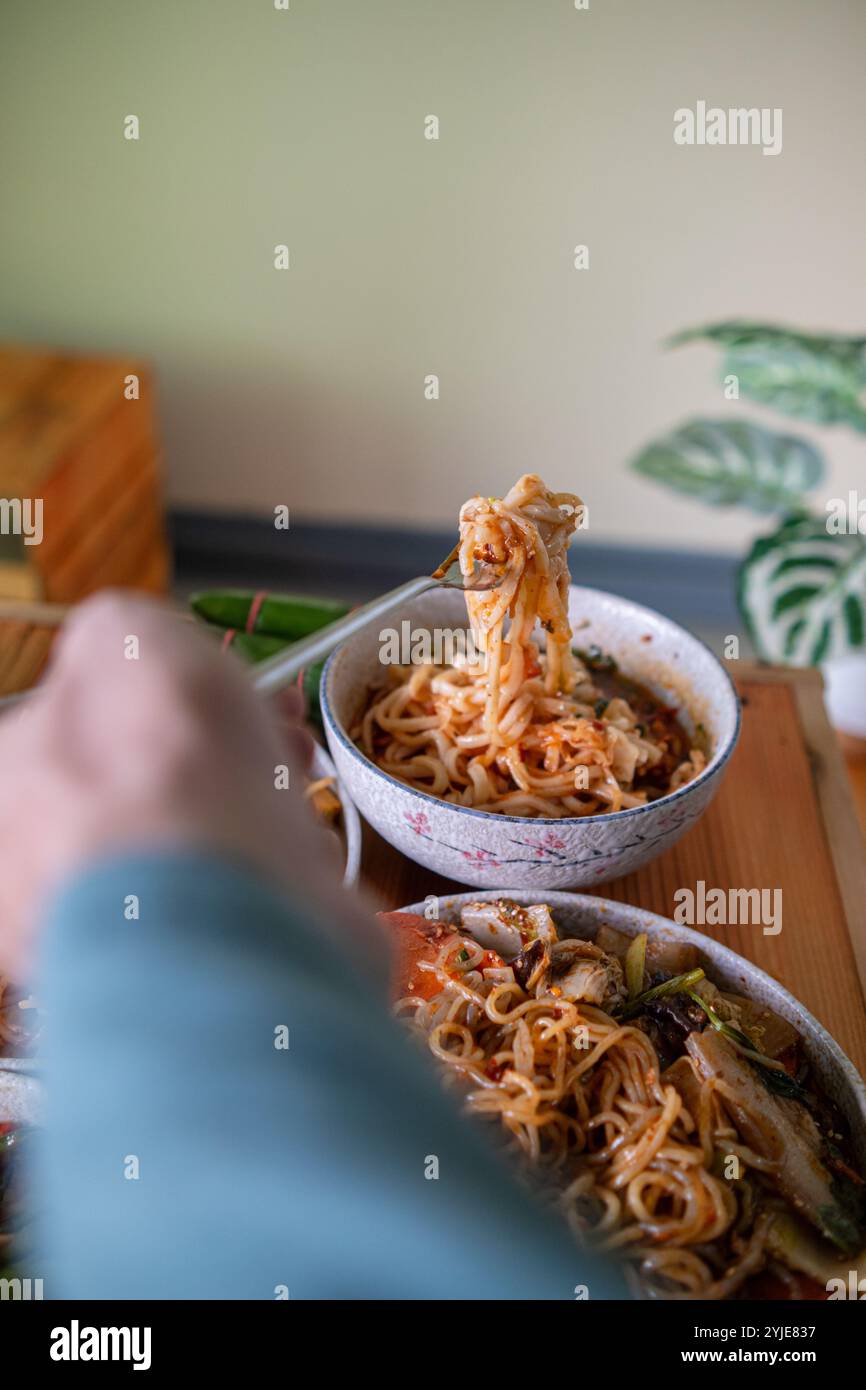 Khao Soi Chiang Tung is served in a bowl with sticky rice noodles and a ...