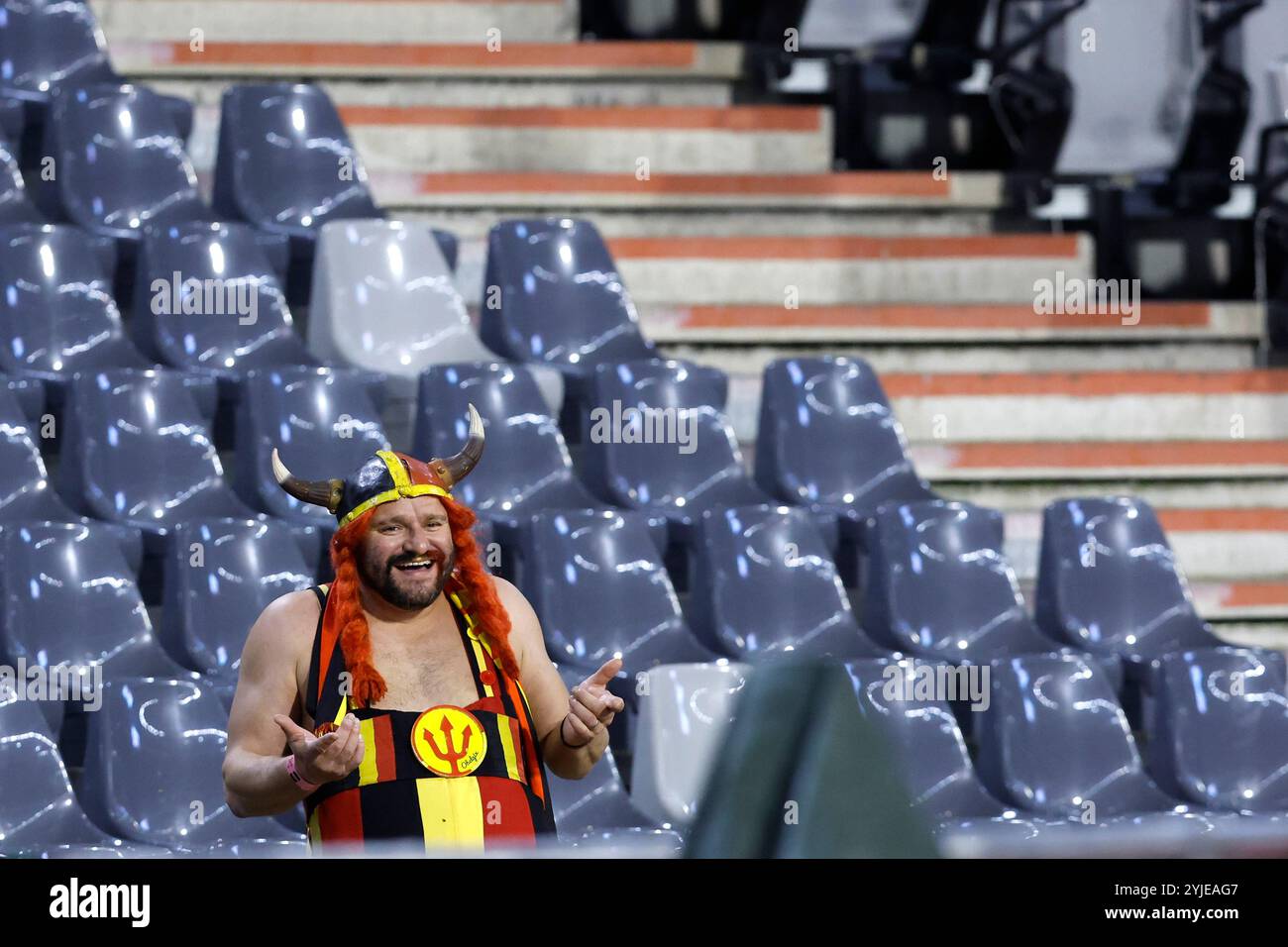 A fan of Belgium wears a costume in the stands as he waits for the ...