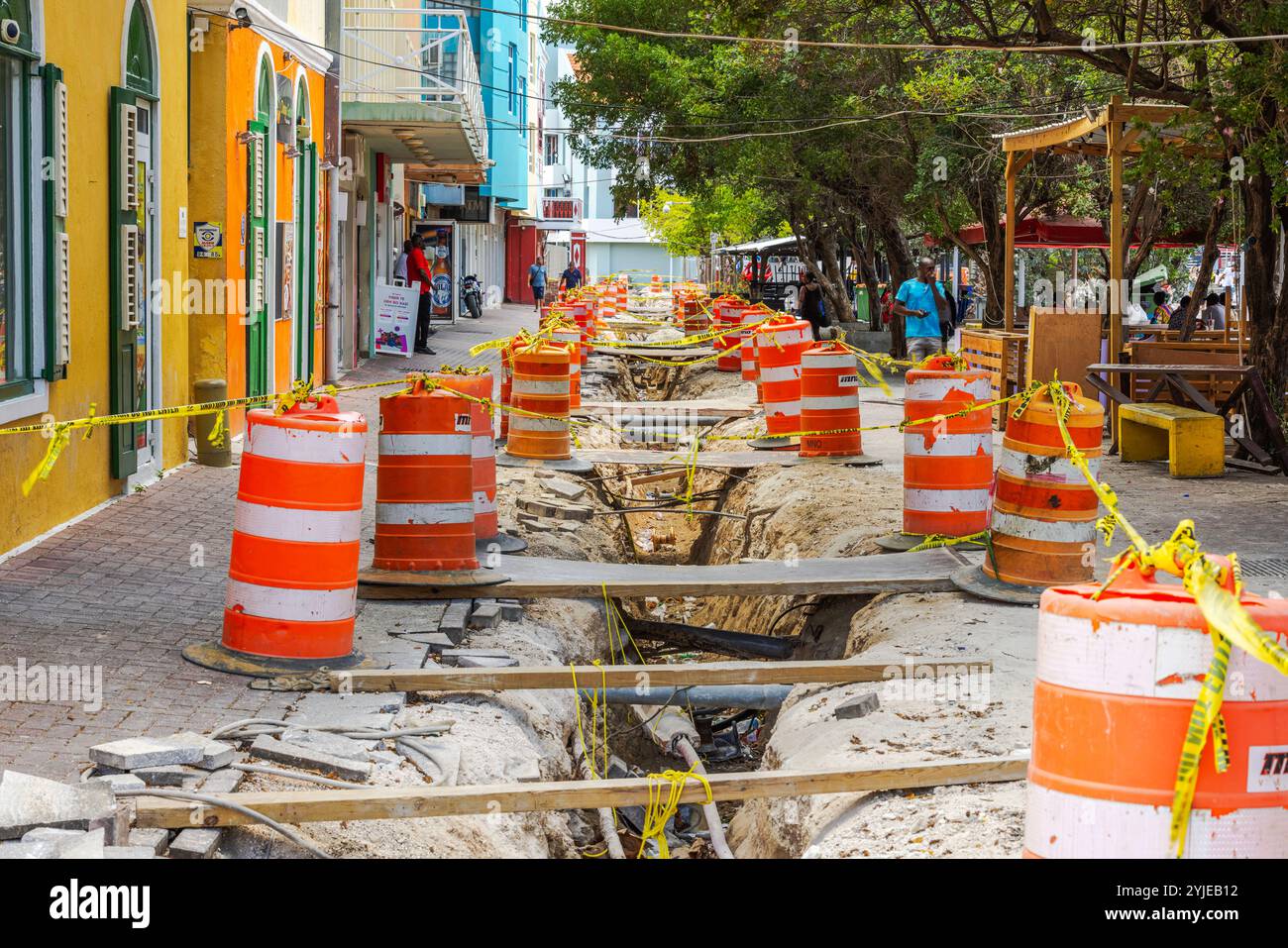 Urban street construction with safety barriers and caution tape in ...
