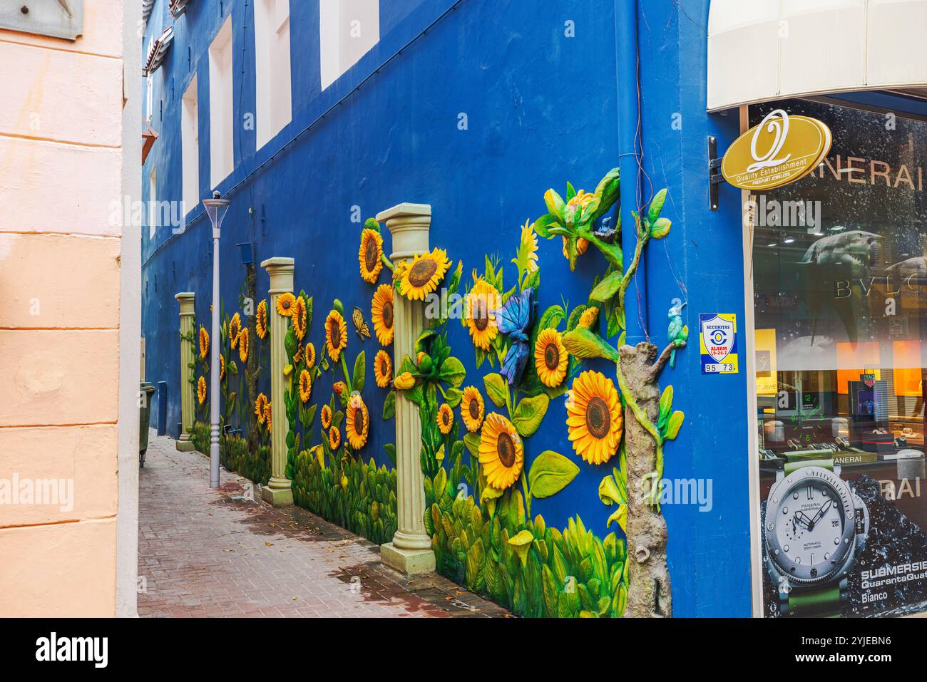 Colorful sunflower mural decorates alleyway wall near storefront in ...