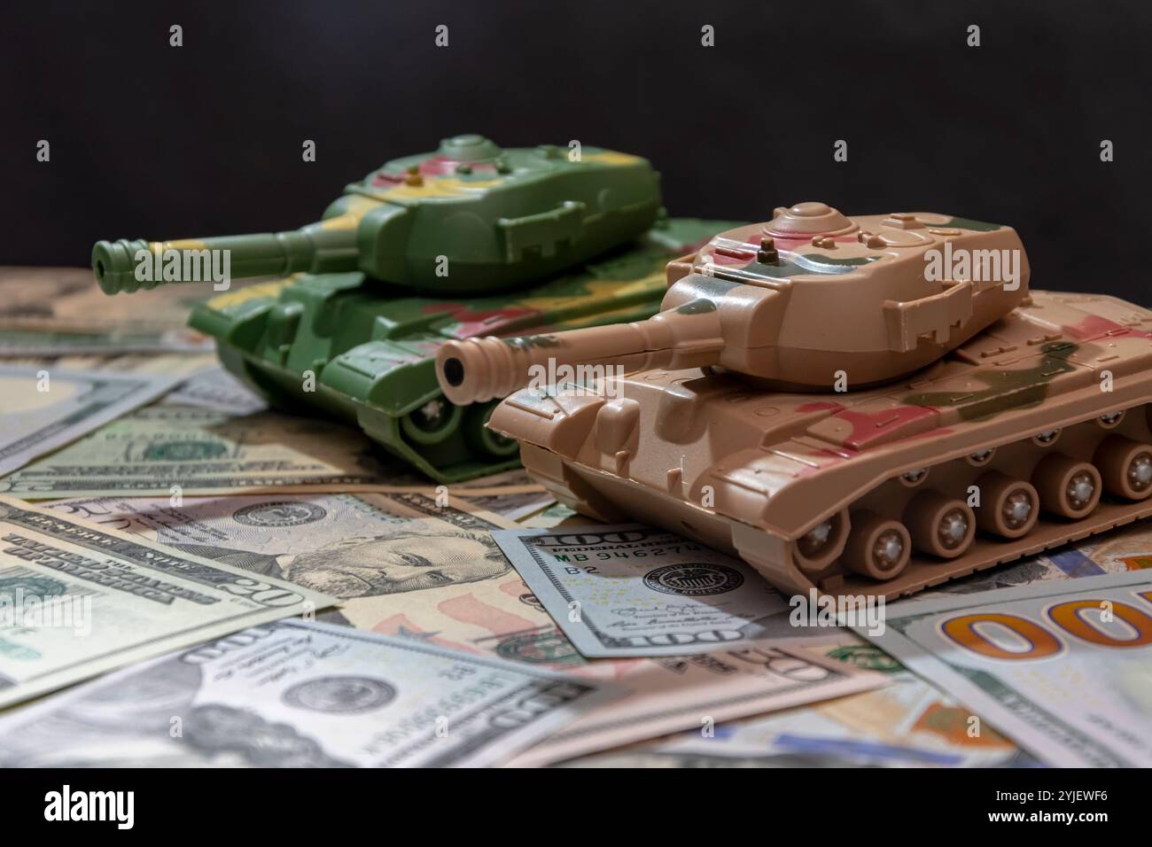 Two military tanks, American dollars, close-up. Concept: arms spending ...