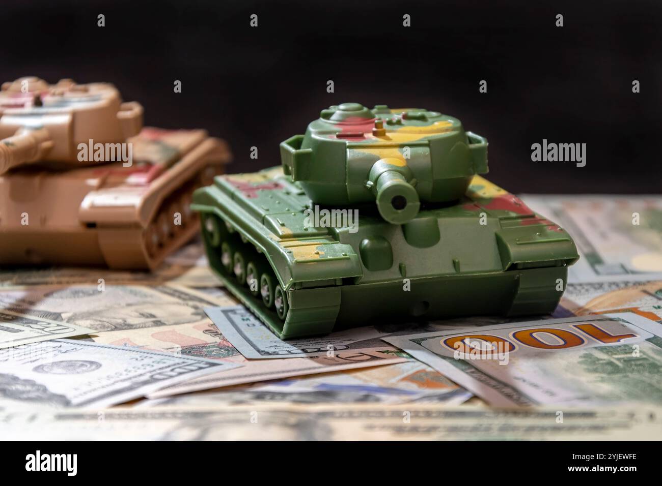 Two military tanks, American dollars, close-up. Concept: arms spending ...