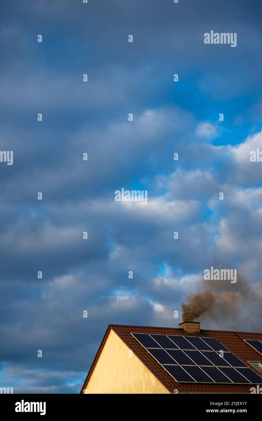 Black smoke from the chimney of a single-family home. Roof covered with ...