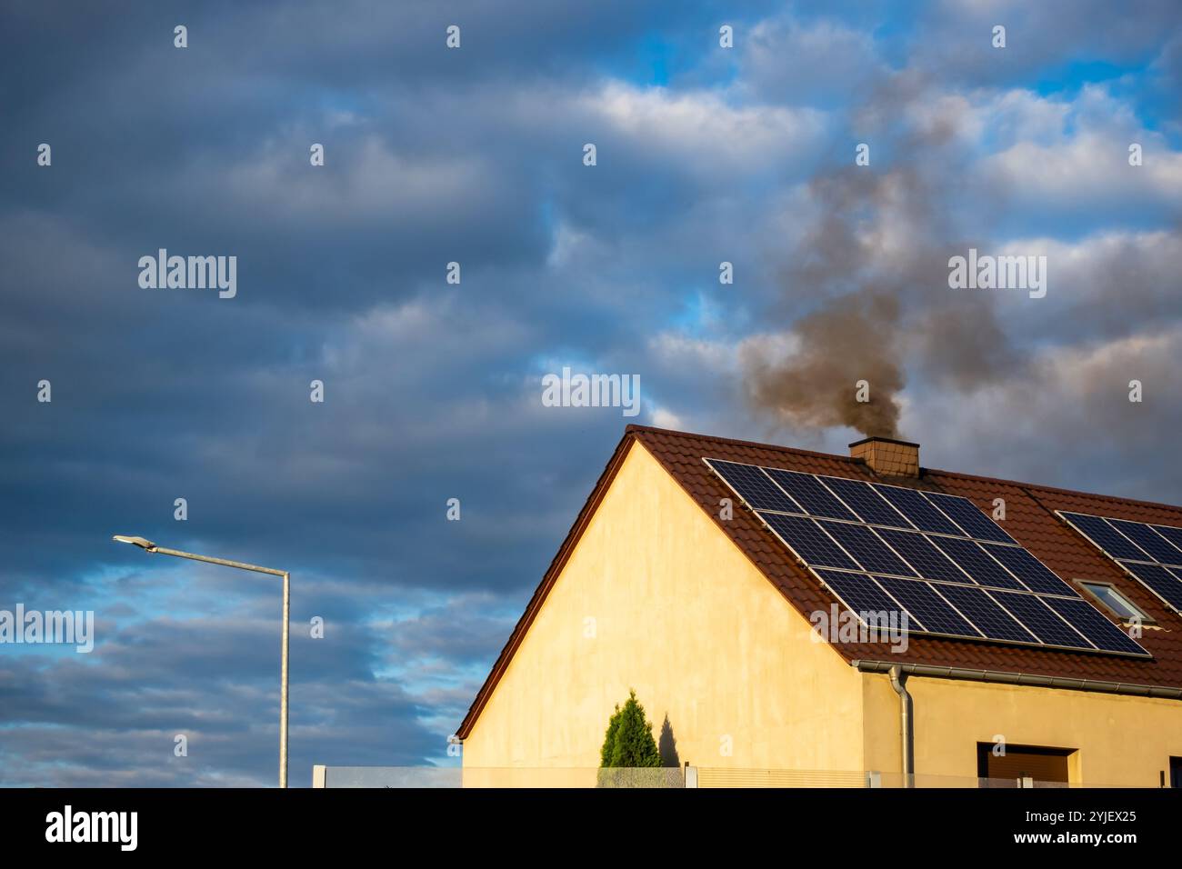 Black smoke from the chimney of a single-family home. Roof covered with ...