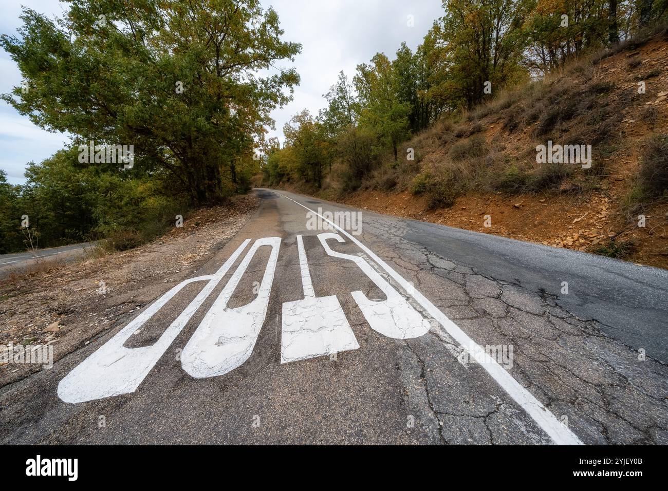 Stop sign painted on the ground on secondary mountain road, Riaza ...