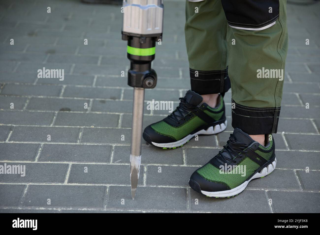 A construction worker using a powerful demolition tool while wearing ...