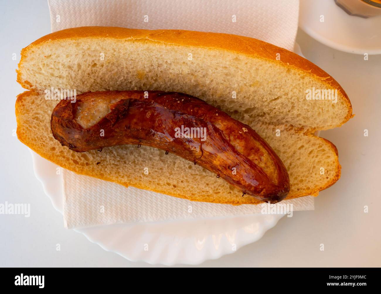 Hearty snack is crispy baguette stuffed with juicy fatty sausages Stock ...