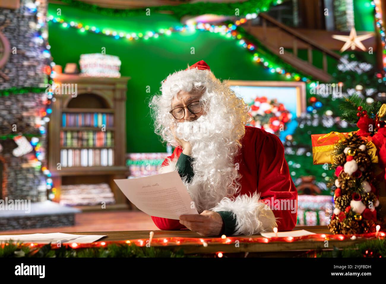Traditional image of Father Christmas reading letters by the fire ...