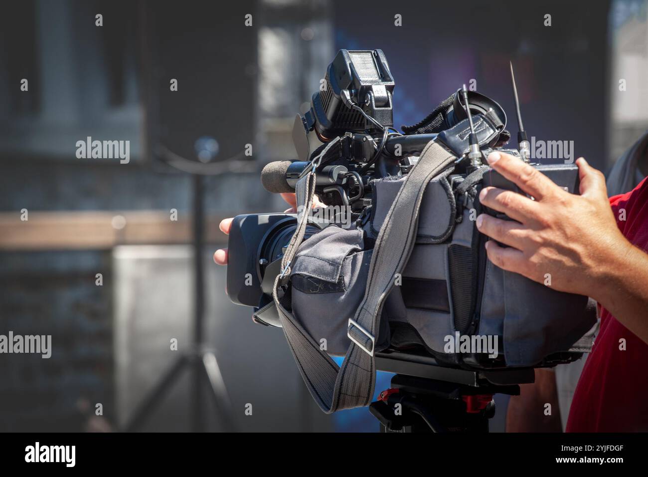 A professional broadcasting camera, filmed outdoors with a selective ...