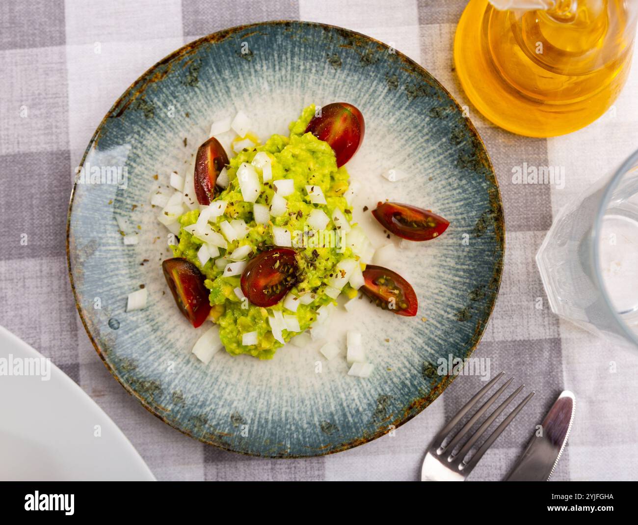 Pile of guacamole on plate, sprinkled with chopped hot onions ...