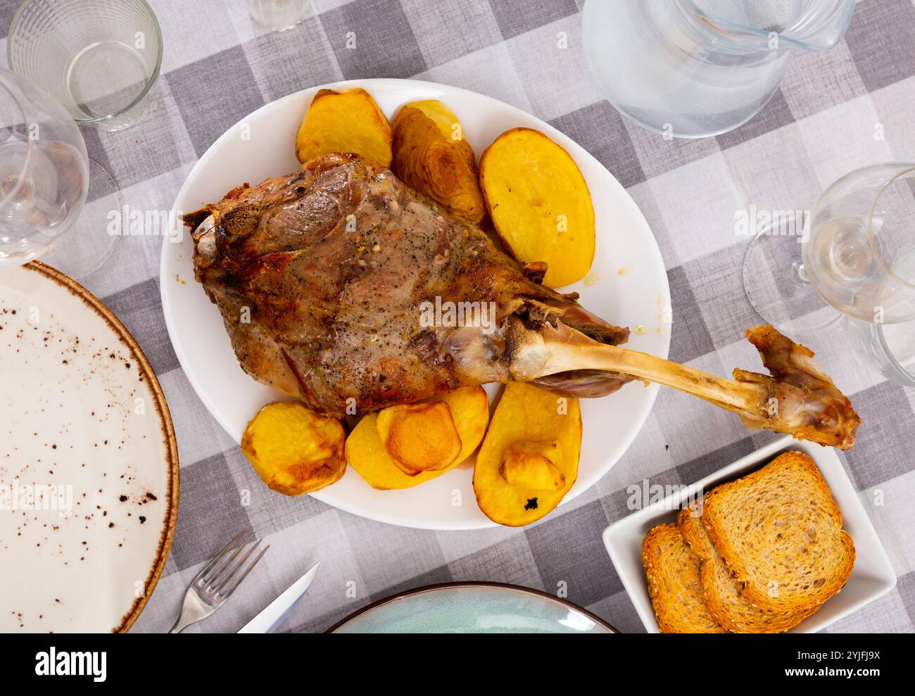 Traditional Spanish lunch is served - fried baked leg of lamb with side ...