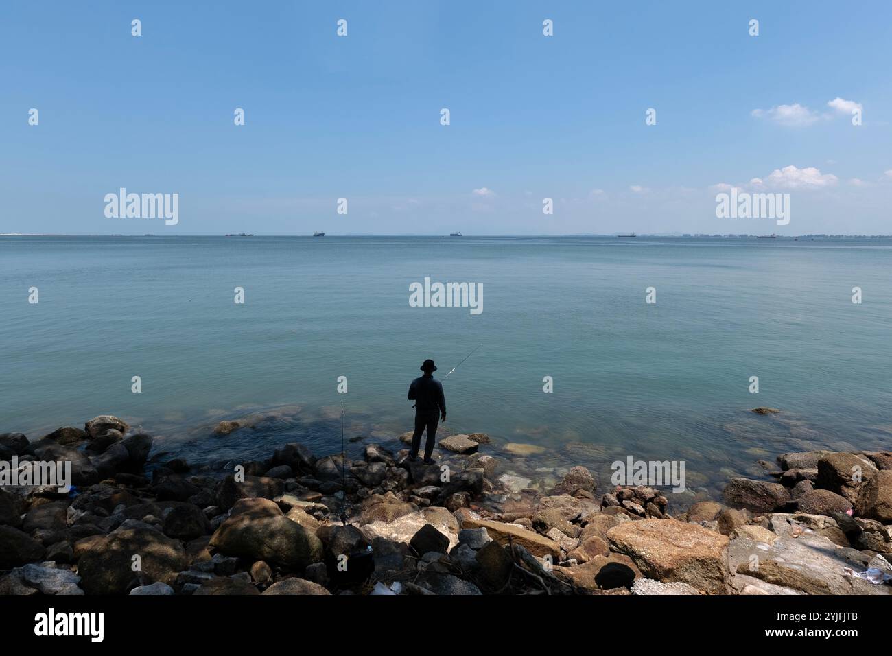 An unidentified angler fishing on a rocky patch in front of the Malacca ...
