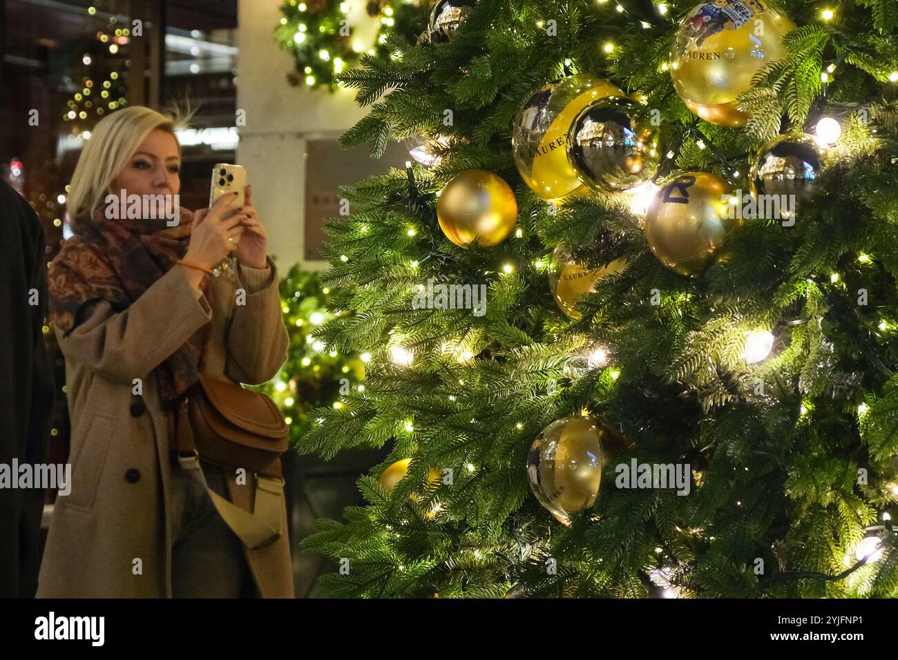 London, UK. 14th November, 2024. A visitor takes a photo of a Christmas tree outside the Ralph ...