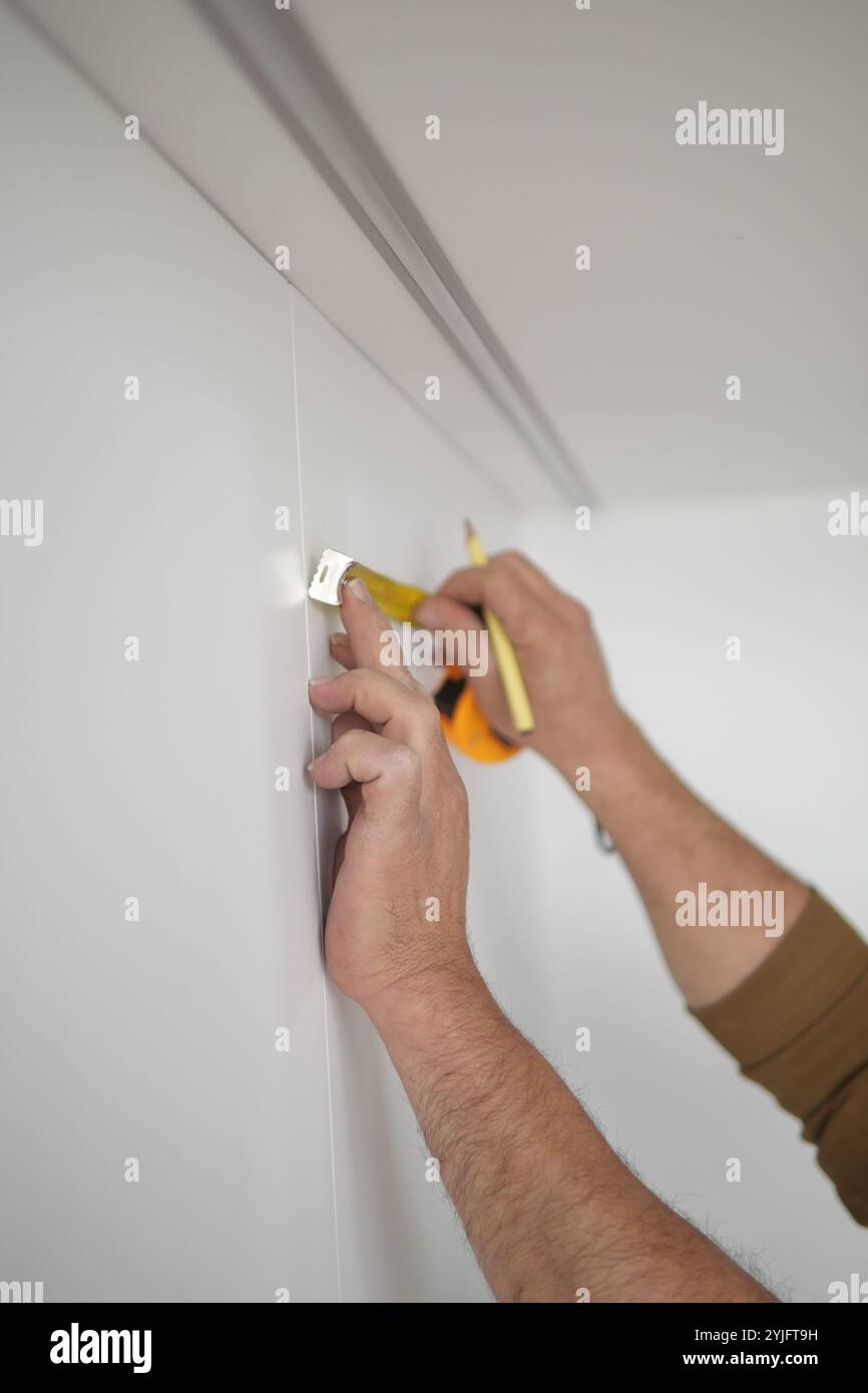 Man measuring wall with a tape measure Stock Photo - Alamy