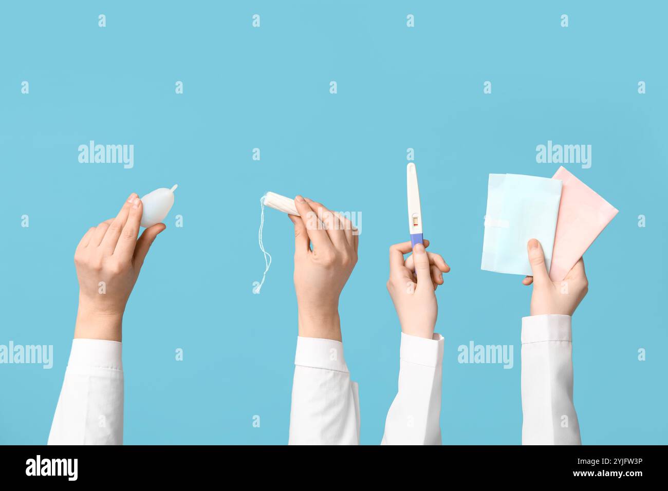 Doctor's hands with menstrual cup, tampon, pads and pregnancy test on ...