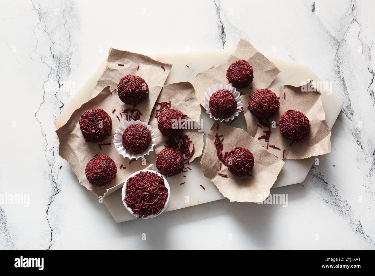 Board with delicious chocolate truffles and torn pieces of paper on ...