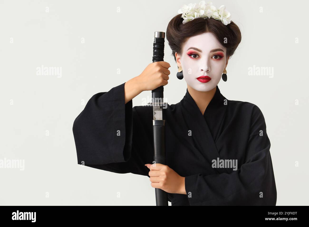 Beautiful young geisha with katana on white background Stock Photo - Alamy