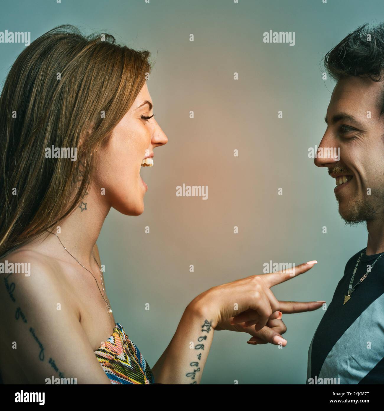 woman playfully teases the man, mocking him and pointing at him. His ...