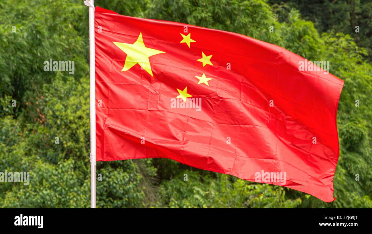 Chinese flag gently waving against the green forest in Chengdu ...