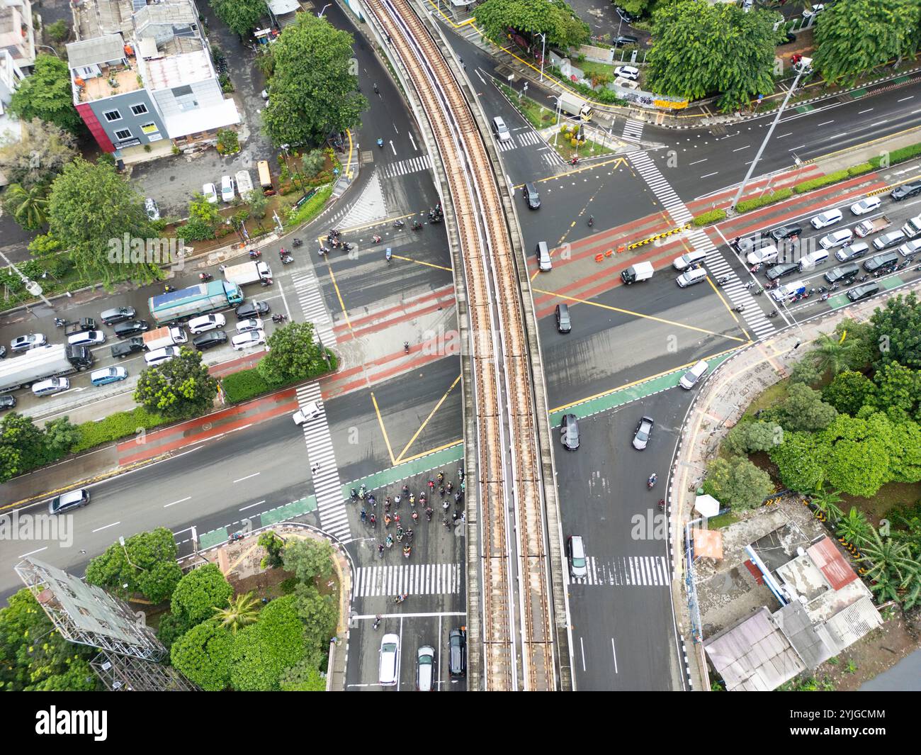 Aerial view of a busy intersection in Jakarta, elevated train tracks, traffic, and city streets ...