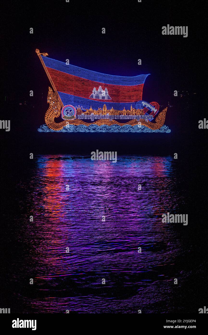 an Illuminated float / barge casts its reflection on the Tonle Sap ...