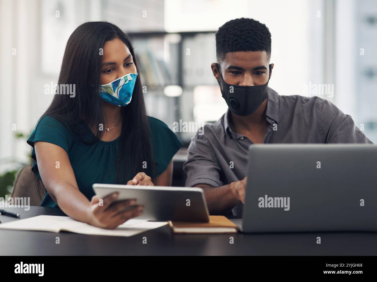 Office, face mask and business people with laptop for discussion ...
