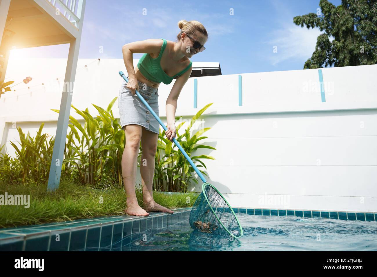 Woman cleaning swimming pool hi-res stock photography and images - Alamy