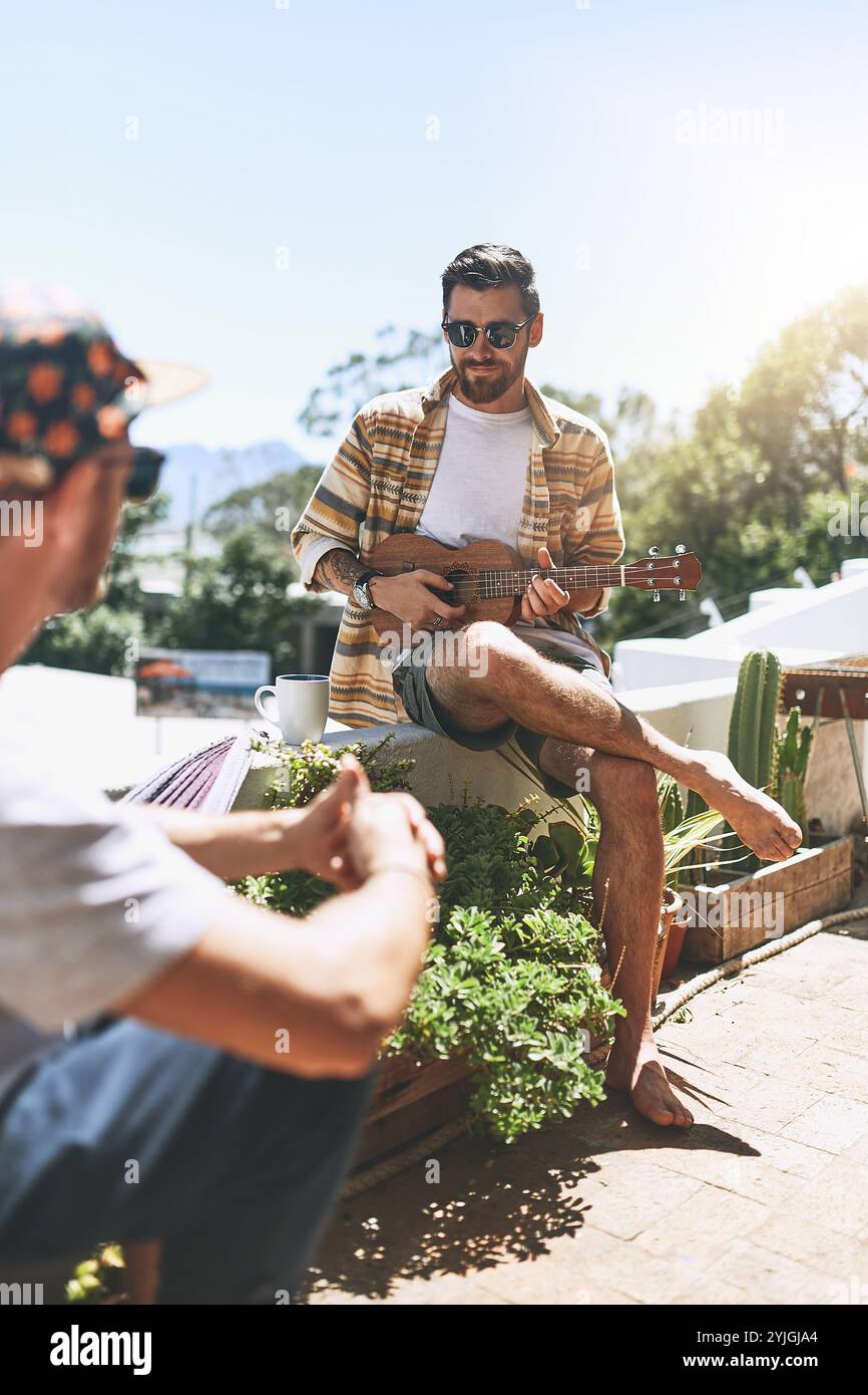 Friends, balcony and men with ukulele for music in backyard for ...