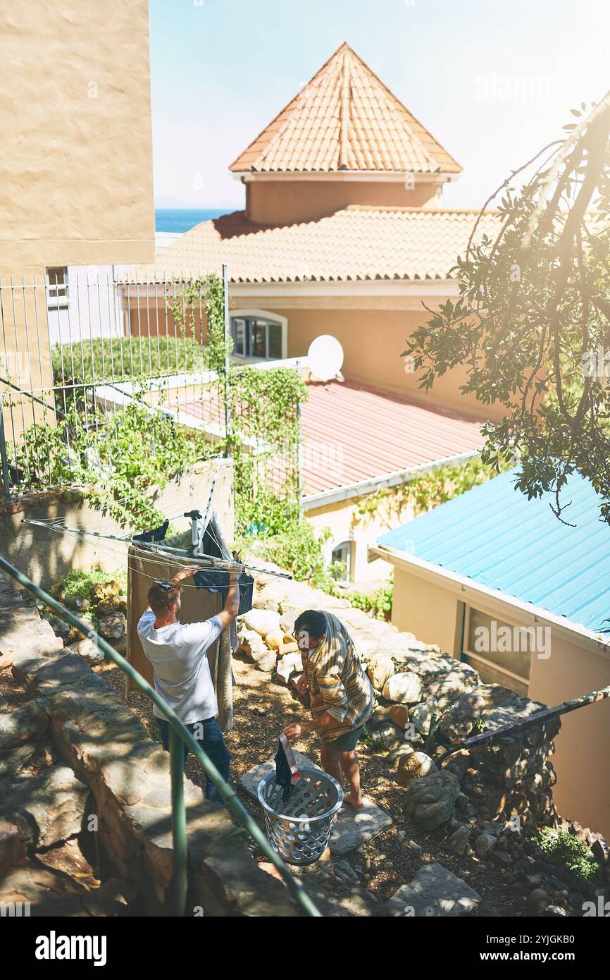 Laundry, above and men with clothes on clothesline in backyard for ...