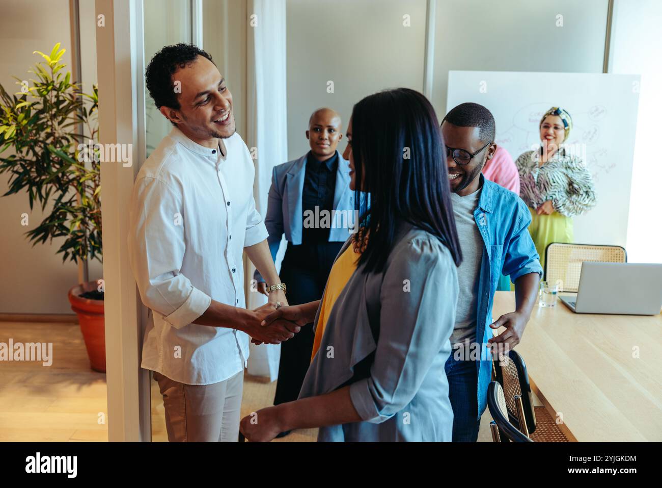 A diverse business team meets with a client in a modern office ...