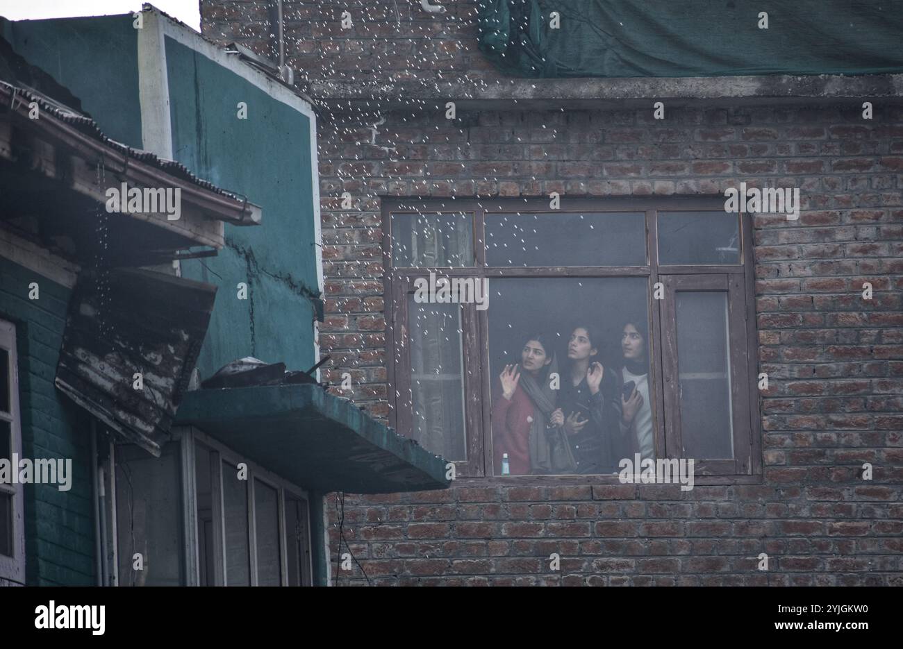 People are watching from windows while fire fighters struggle extinguish fire that broke out in ...