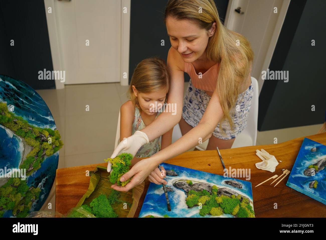 A mother and her daughter craft vibrant natural landscapes Stock Photo ...