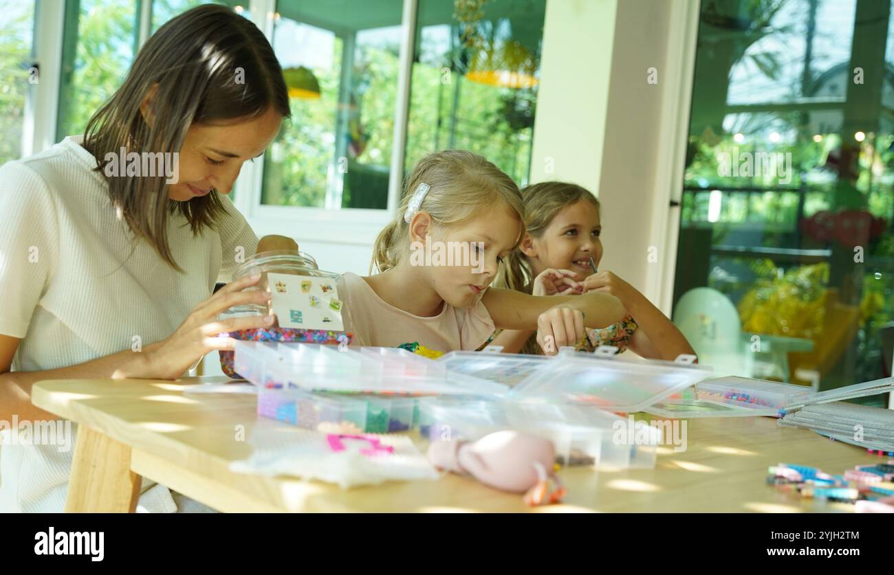 Teacher in workshop teched two girls how to assemble a thermo mosaic ...