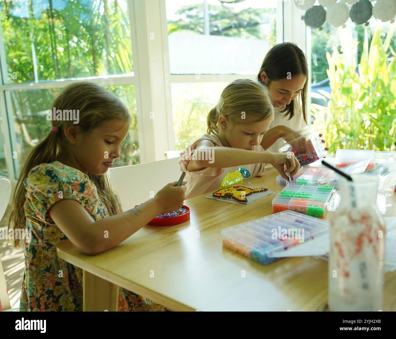 Teacher in workshop teched two girls how to assemble a thermo mosaic ...