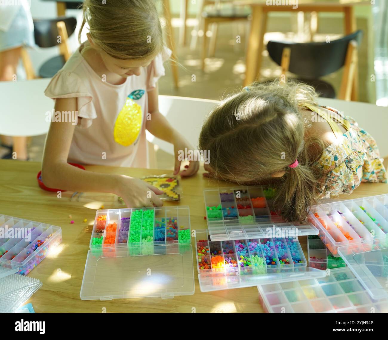 Teacher in workshop teched two girls how to assemble a thermo mosaic ...