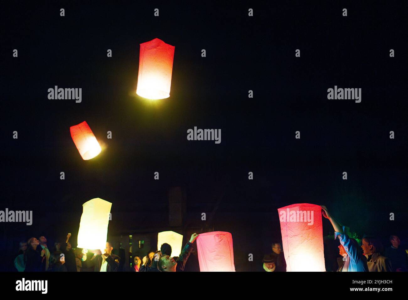 A vibrant display of red and yellow lanterns gliding silently through ...
