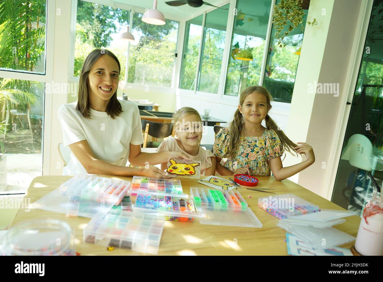 Teacher in workshop teched two girls how to assemble a thermo mosaic ...